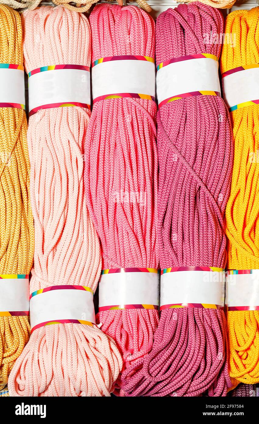 Rolls of polyester cord in various colors of pink shades, rolled into a ...