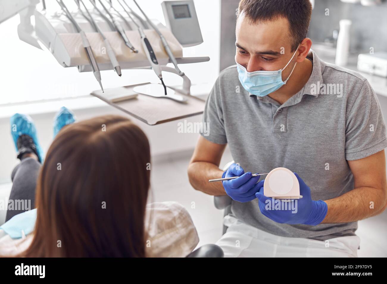 Cheerful positive dentist and client in dentistry. They look at each ...