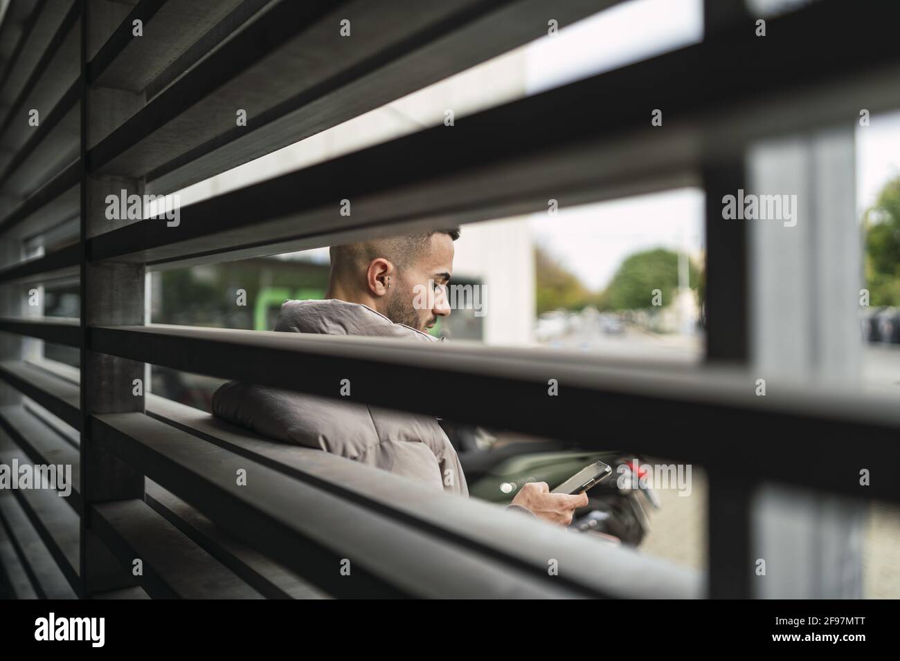 Young man leaning on a metal fence hi-res stock photography and images - Alamy