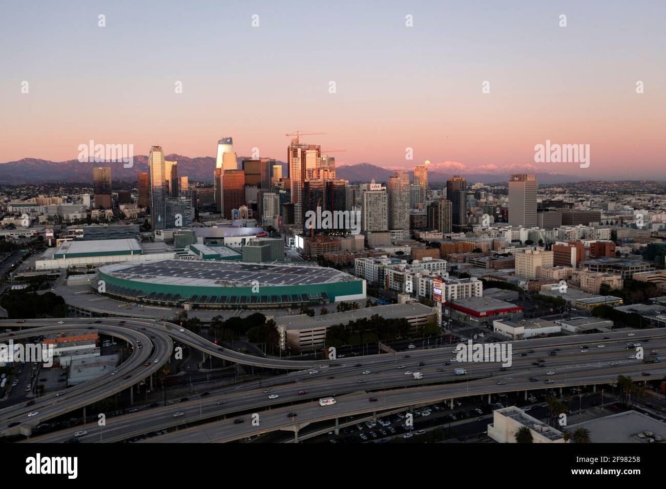 Dusk with moon rising over the mountains behind downtown Los Angeles ...