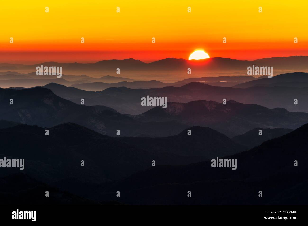Red sun in the end of mountain range Stock Photo - Alamy