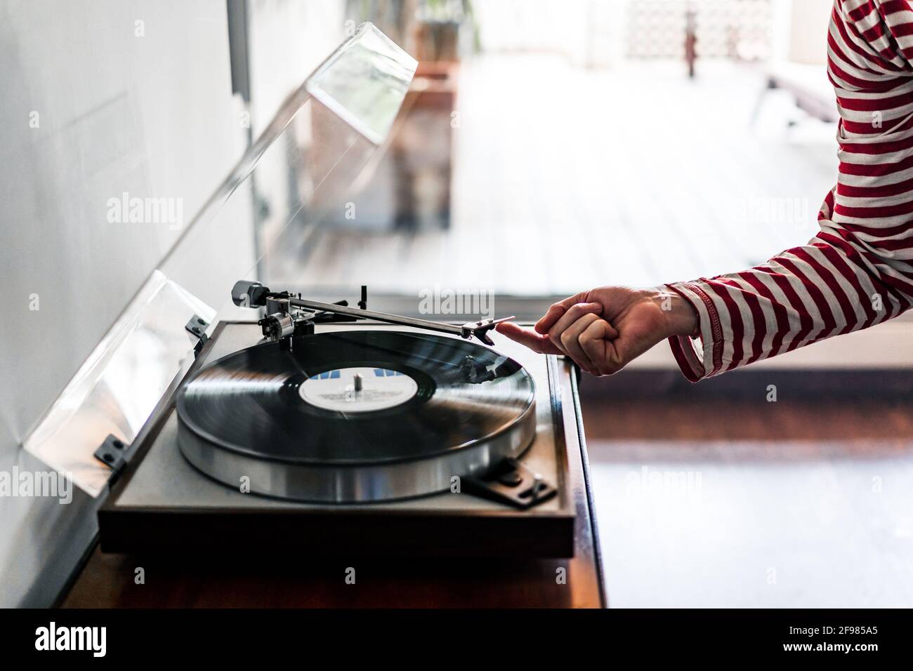 woman putting a vinyl record on a record player inside a house Stock ...