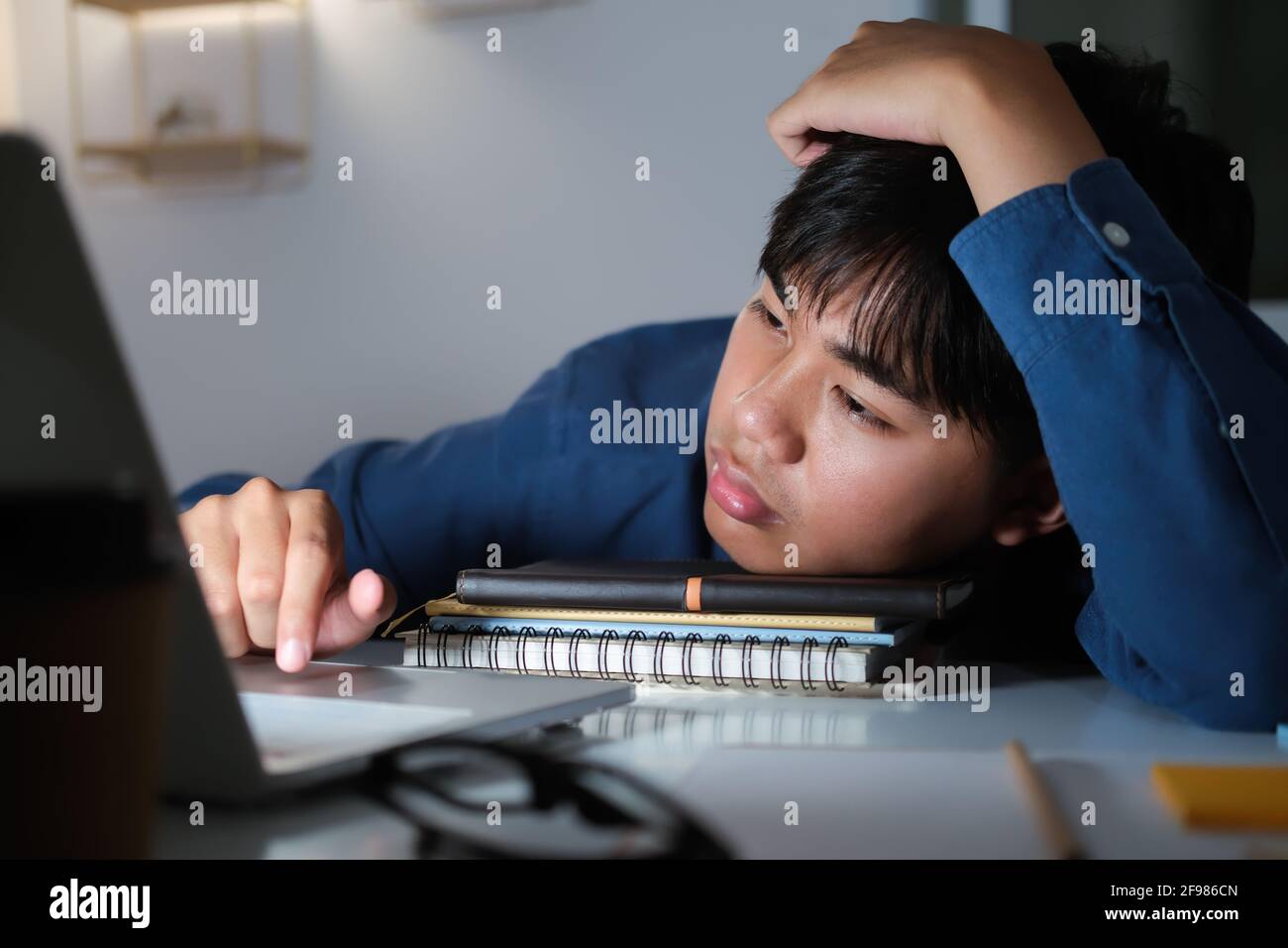 Sleepy exhausted collage young man working overtime Stock Photo - Alamy