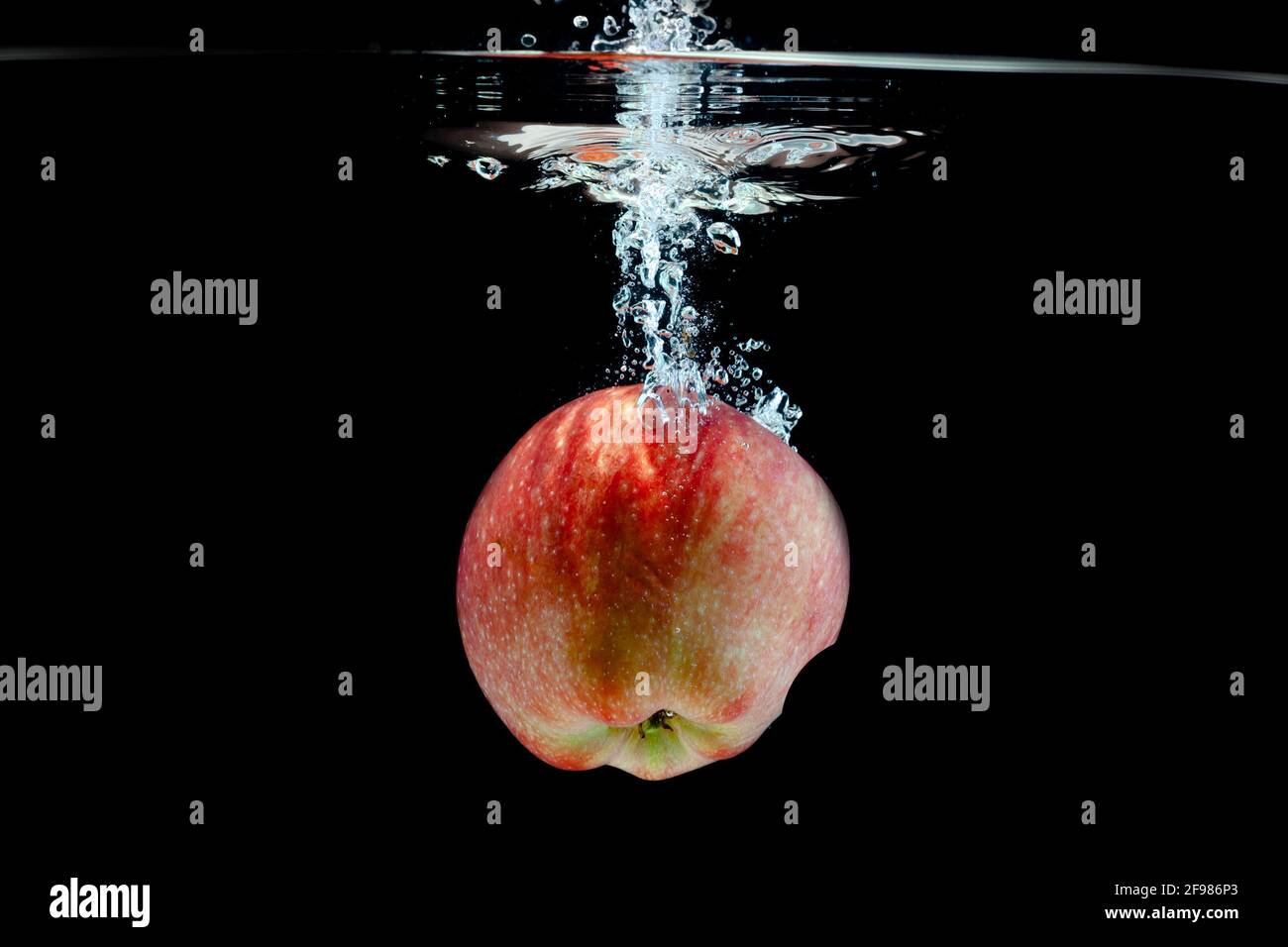 one red ripe apple falls into the water Stock Photo - Alamy