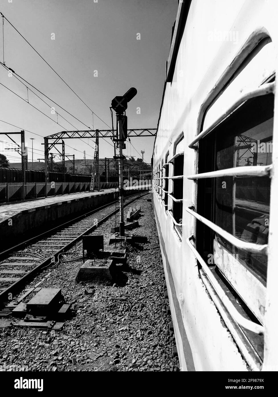 Vertical grayscale shot of an old train with reflections on the window ...