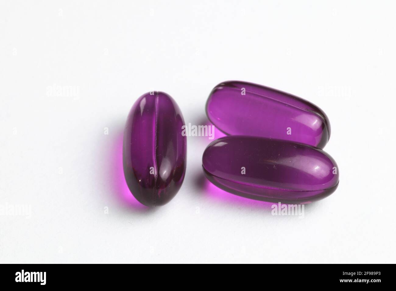purple medicine capsules on white background in center photography ...