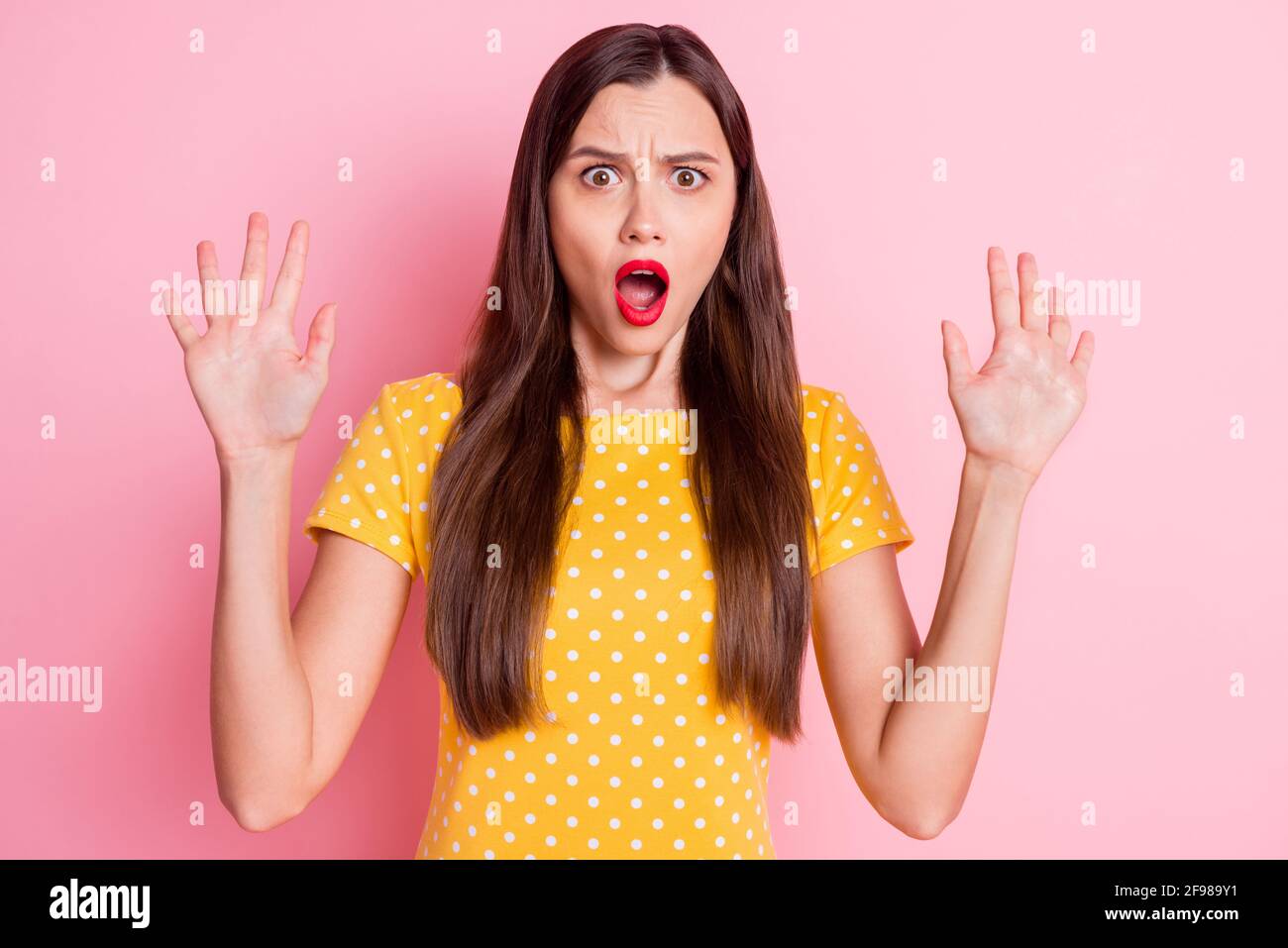 Photo of young amazed girl afraid scared worried nervous panic hands up ...