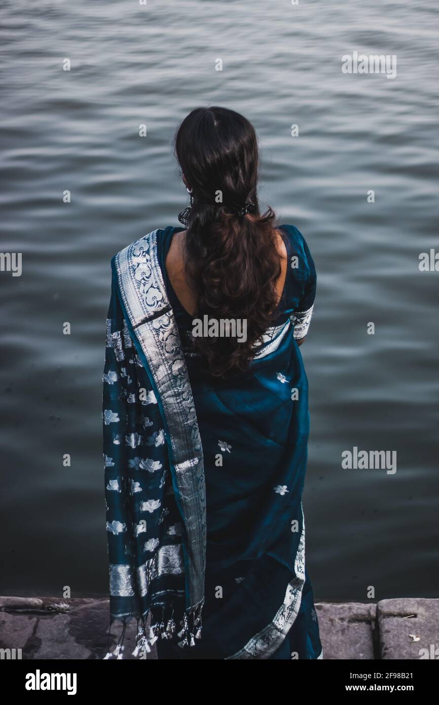 Back view of an Indian female standing on the riverside platform Stock ...