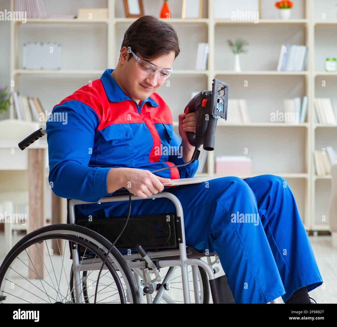 The disabled man working with handsaw at home Stock Photo - Alamy