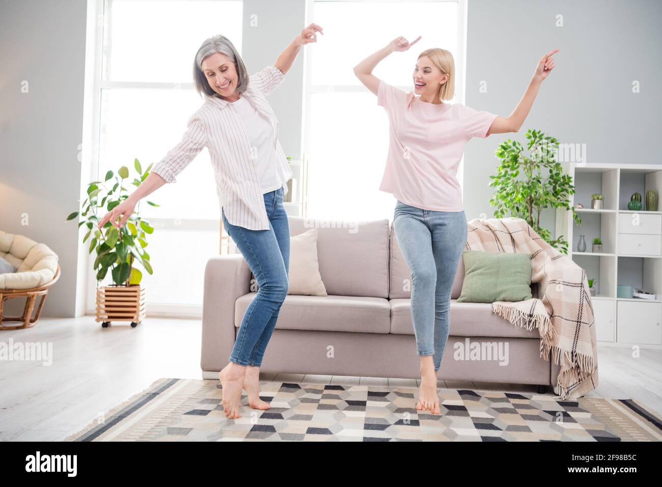 Full length photo of cheerful funky young woman and old lady dance ...