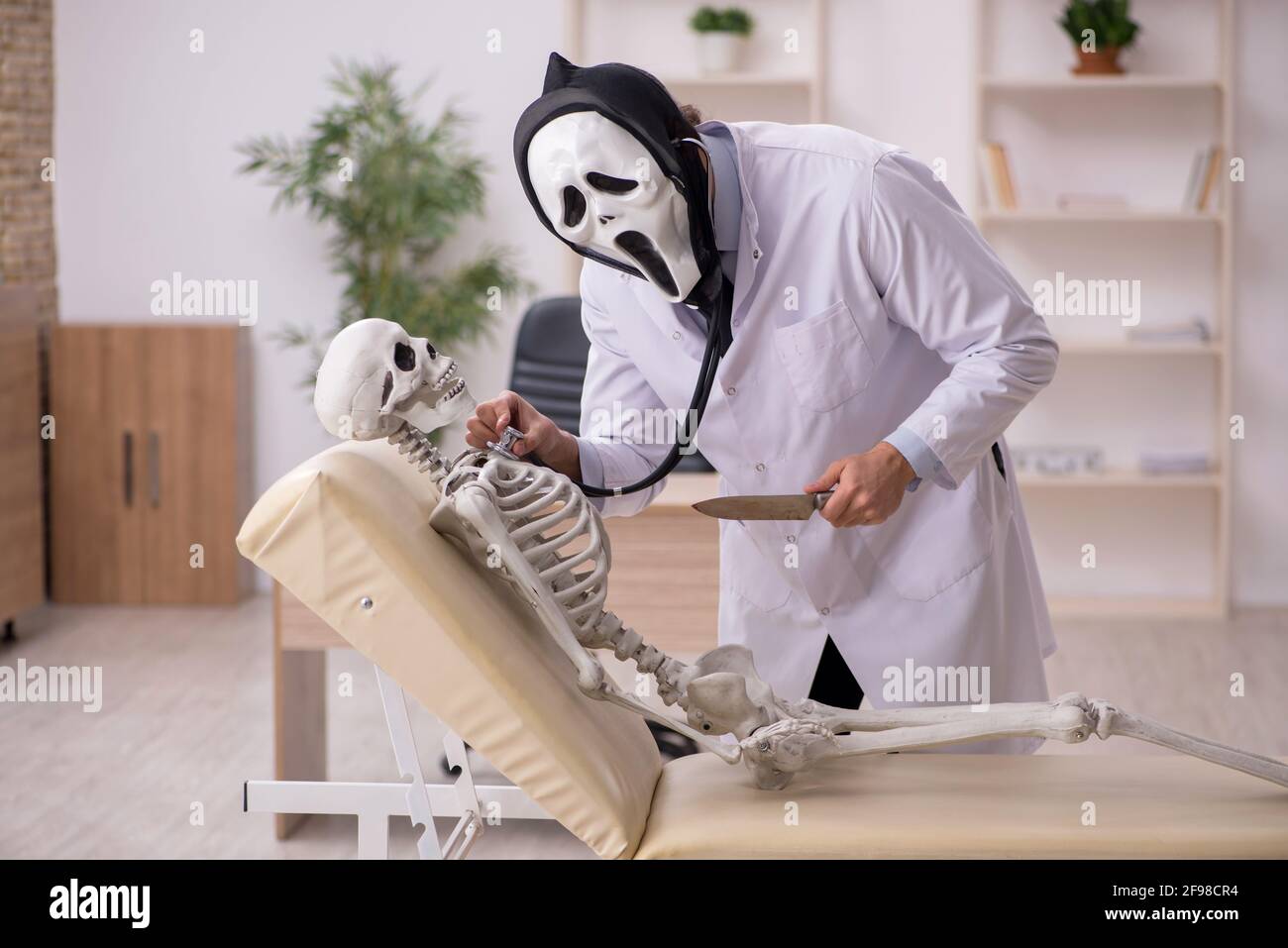 Devil doctor examining skeleton patient in the clinic Stock Photo - Alamy