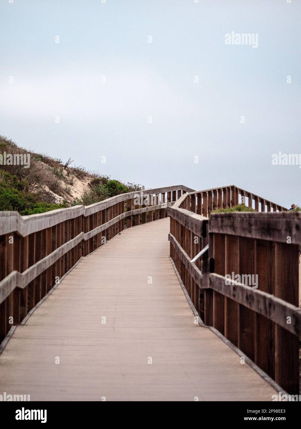 Vertical shot f a bridge on a grassy landscape on a gloomy day Stock ...