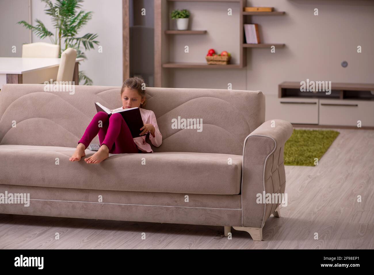 Little girl reading book at home Stock Photo - Alamy