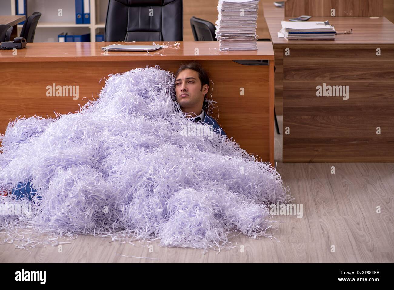 Young male employee cutting papers in the office Stock Photo - Alamy