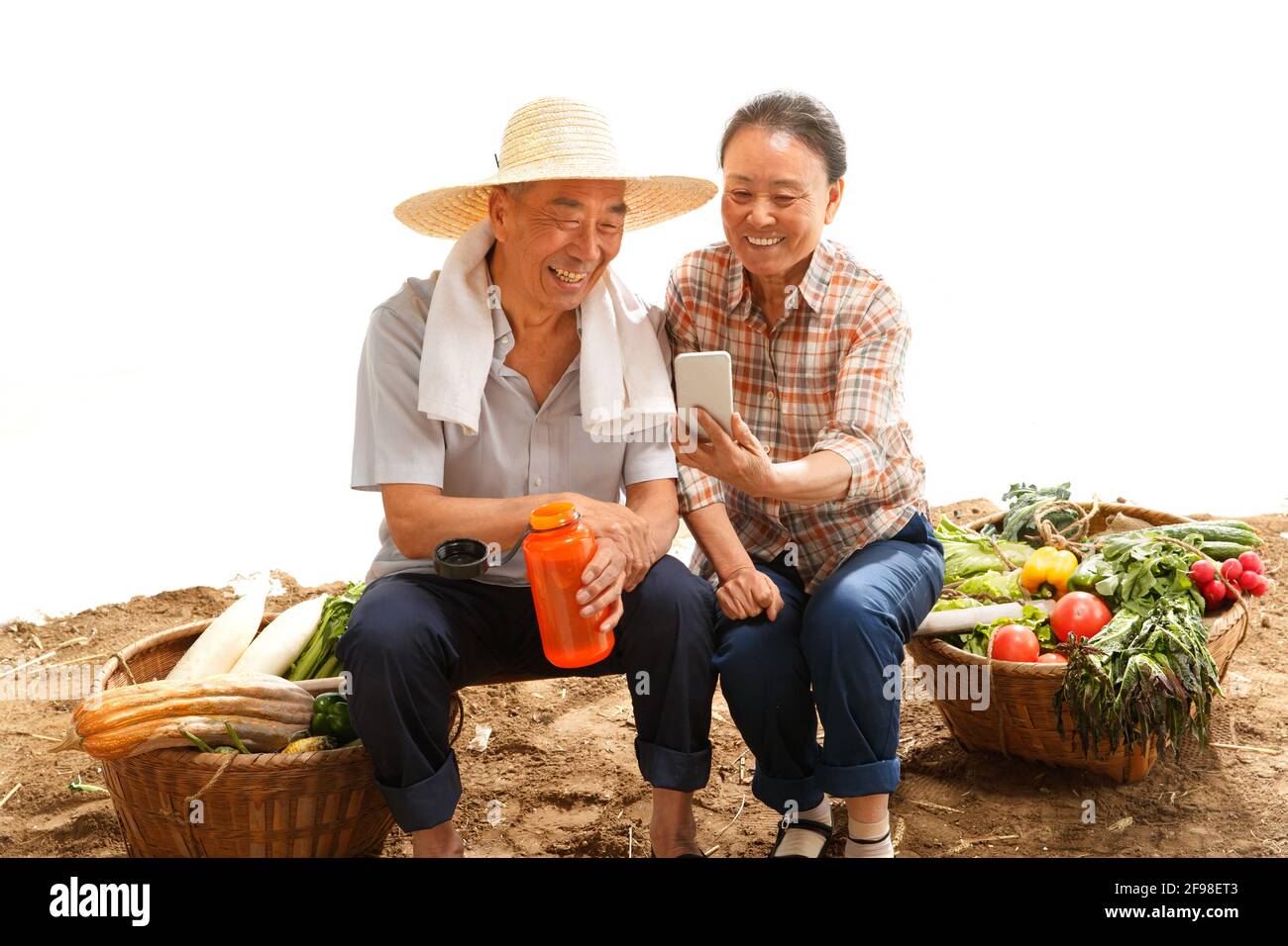 Peasant couple sat in the farm see a mobile phone Stock Photo - Alamy