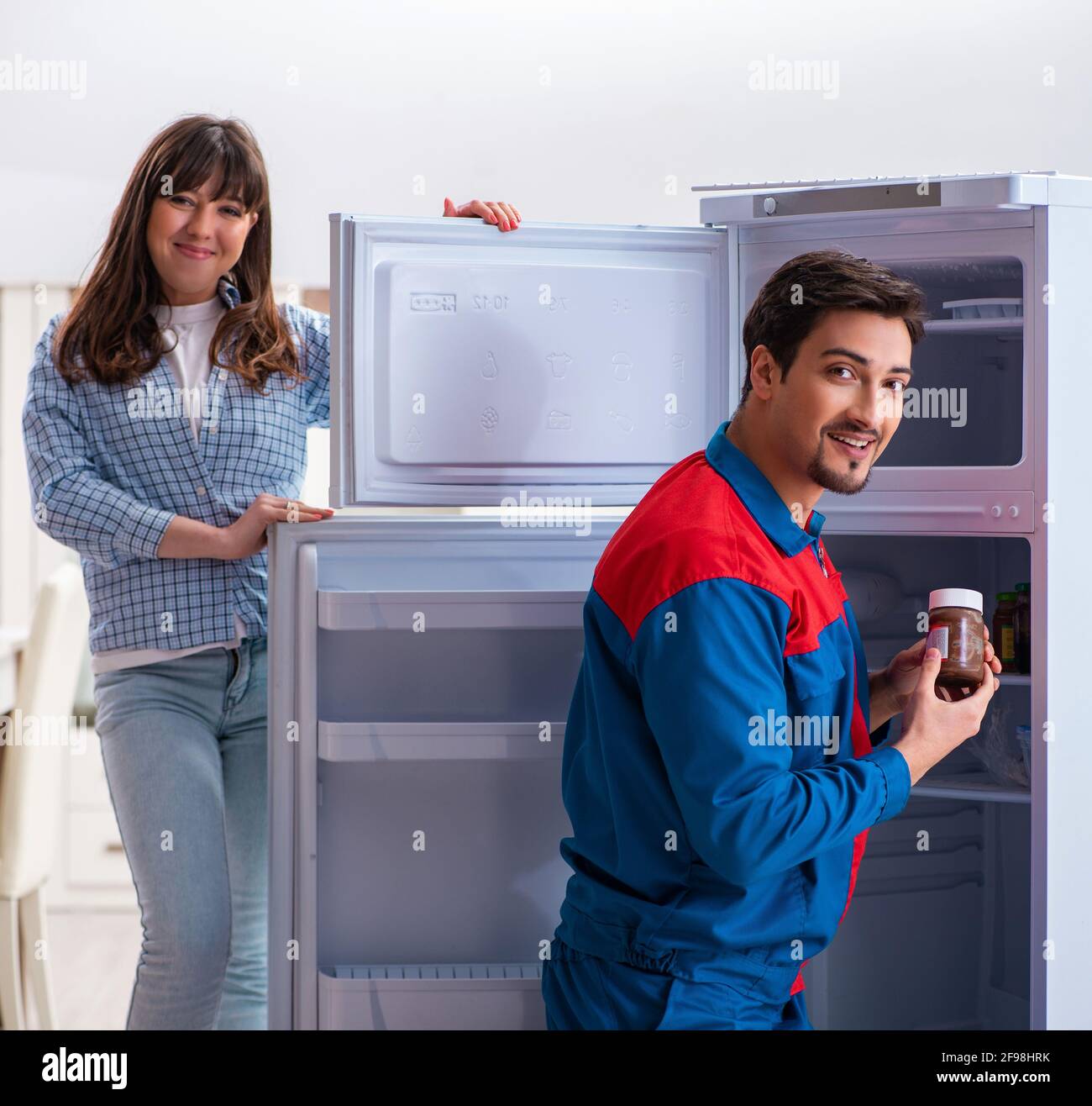 The man repairing fridge with customer Stock Photo - Alamy