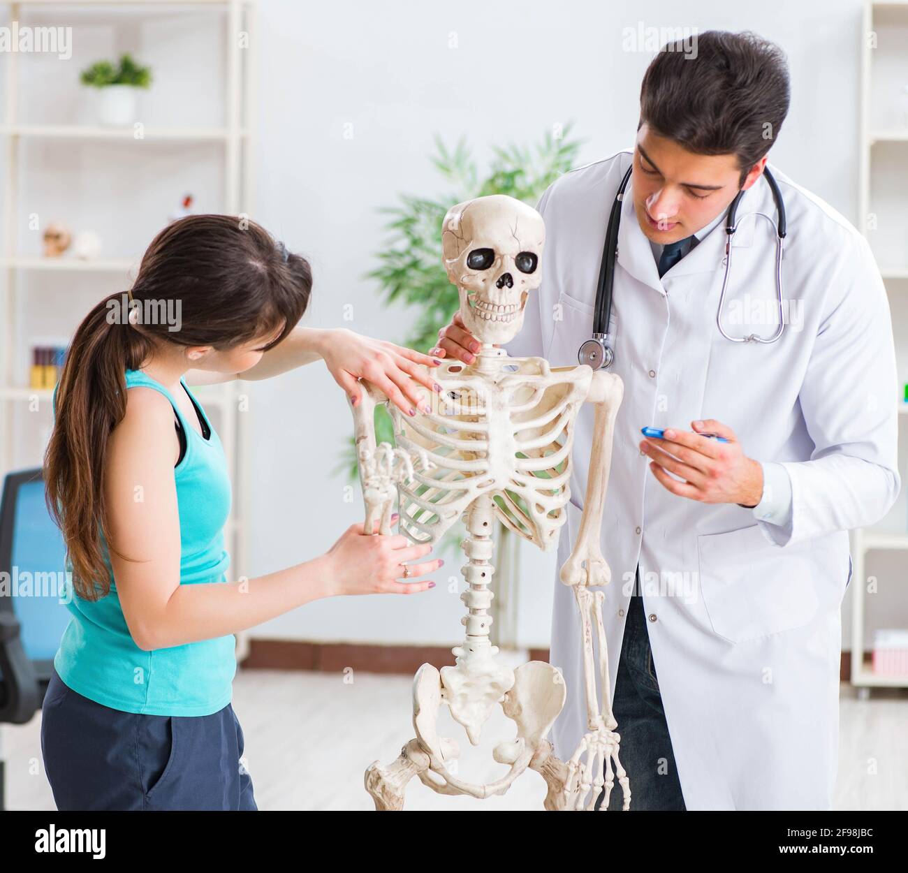 The doctor showing type of injury on skeleton to patient Stock Photo ...