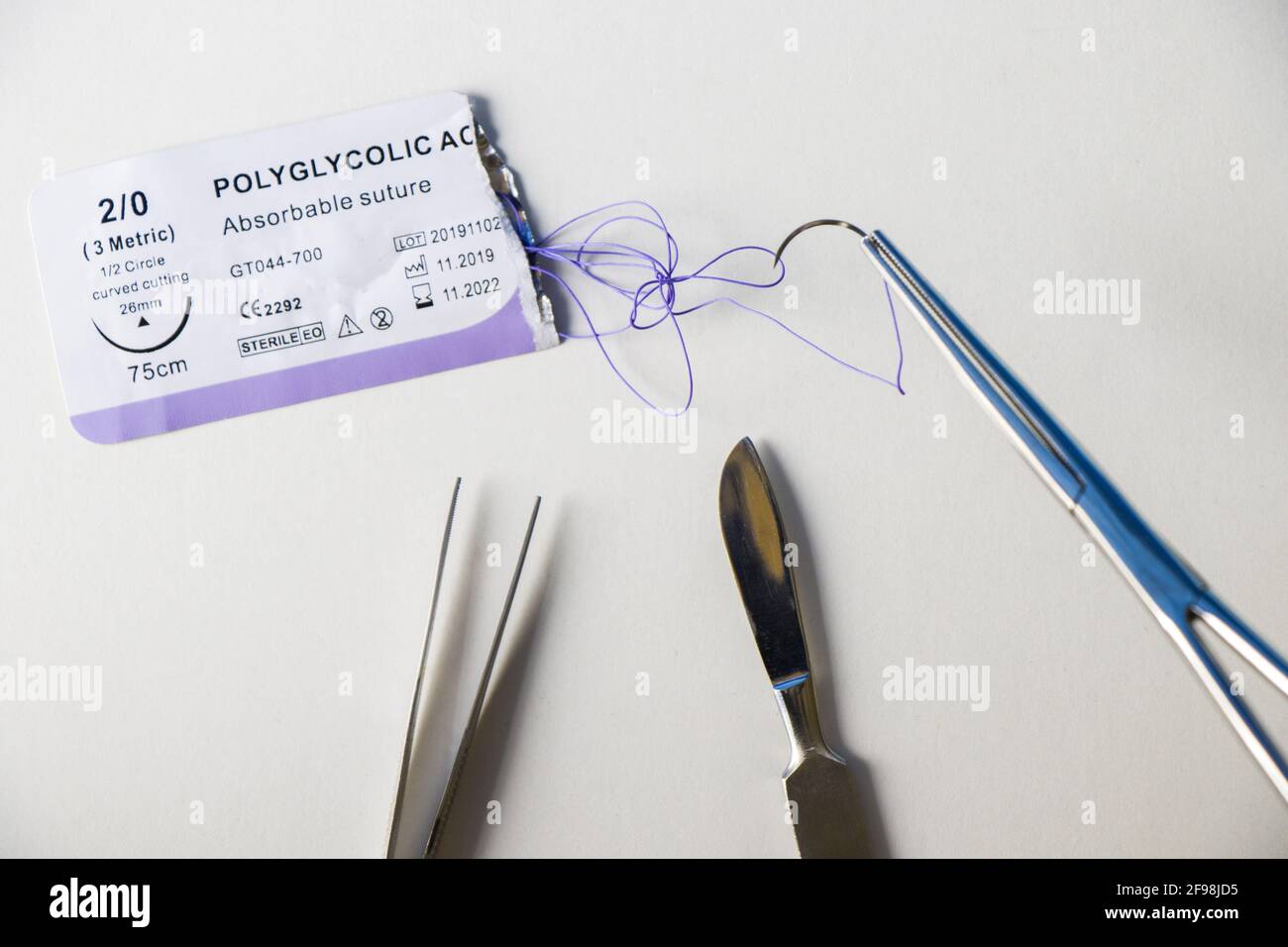 Top view oof a surgical needle and thread with a dissection kit on a ...