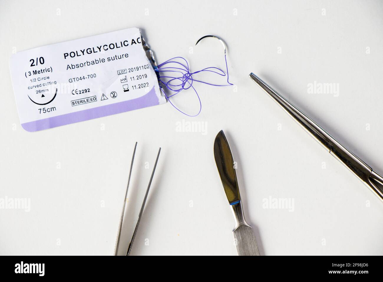 Top view of a surgical needle and thread with a dissection kit on a ...