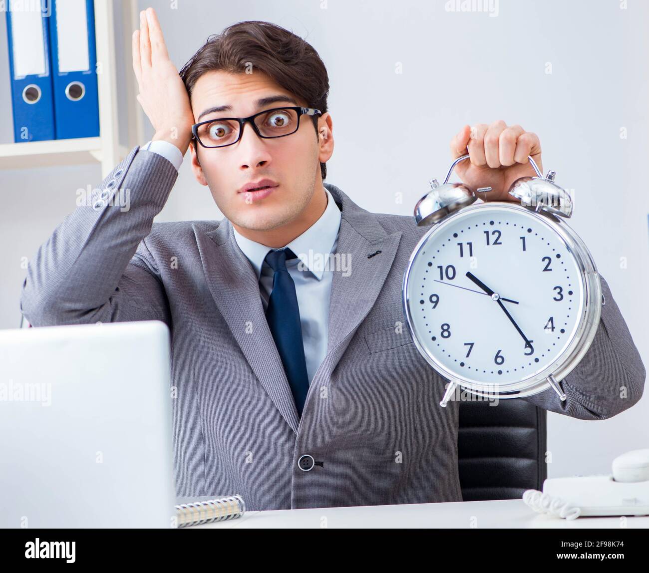 Businessman employee in urgency and deadline concept with alarm clock ...