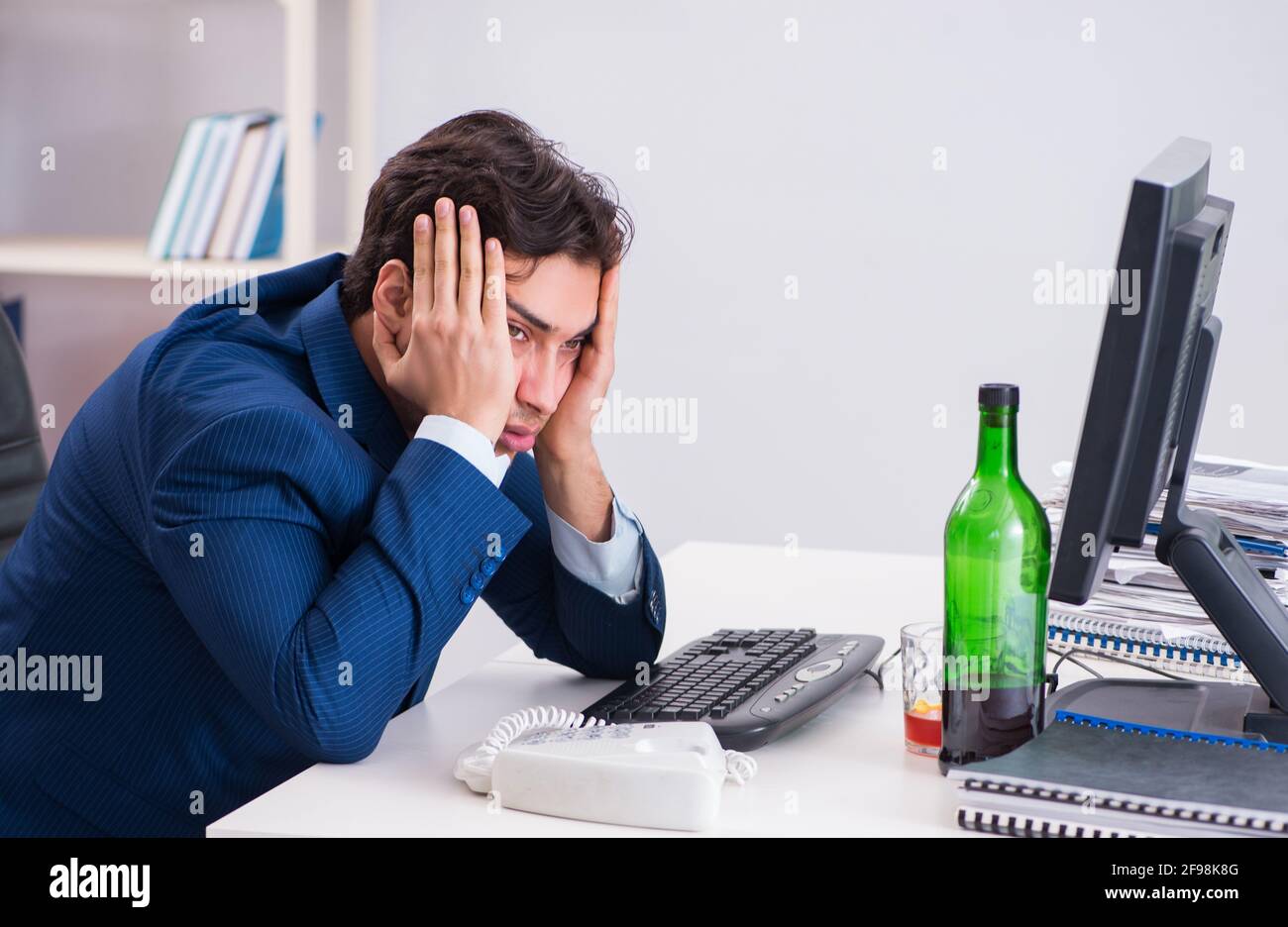 The young businessman employee drinking in the office at desk Stock ...