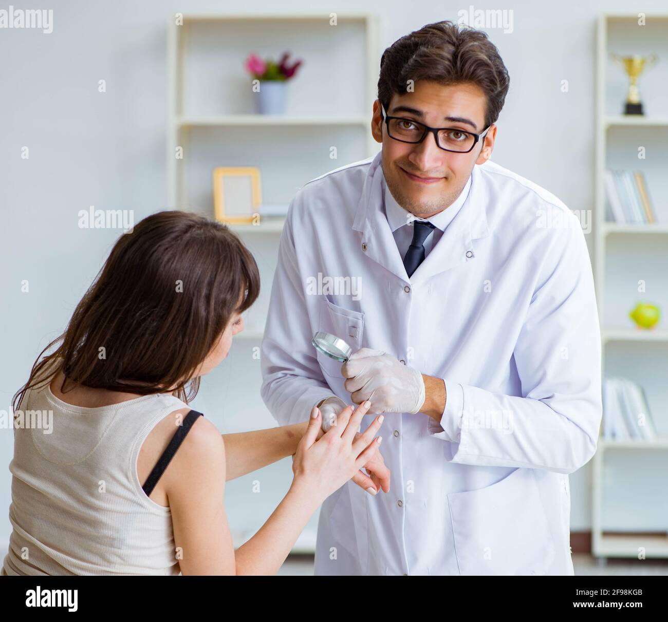 The doctor examining the skin of female patient Stock Photo - Alamy