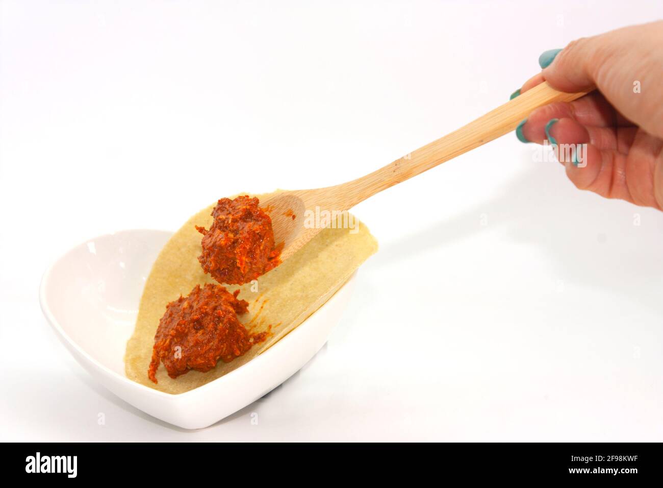 Female hand serving with wooden spoon the Mexican mole gastronomy to ...