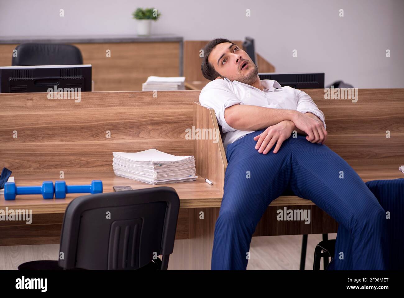 Young male employee doing sport exercises in the office Stock Photo - Alamy