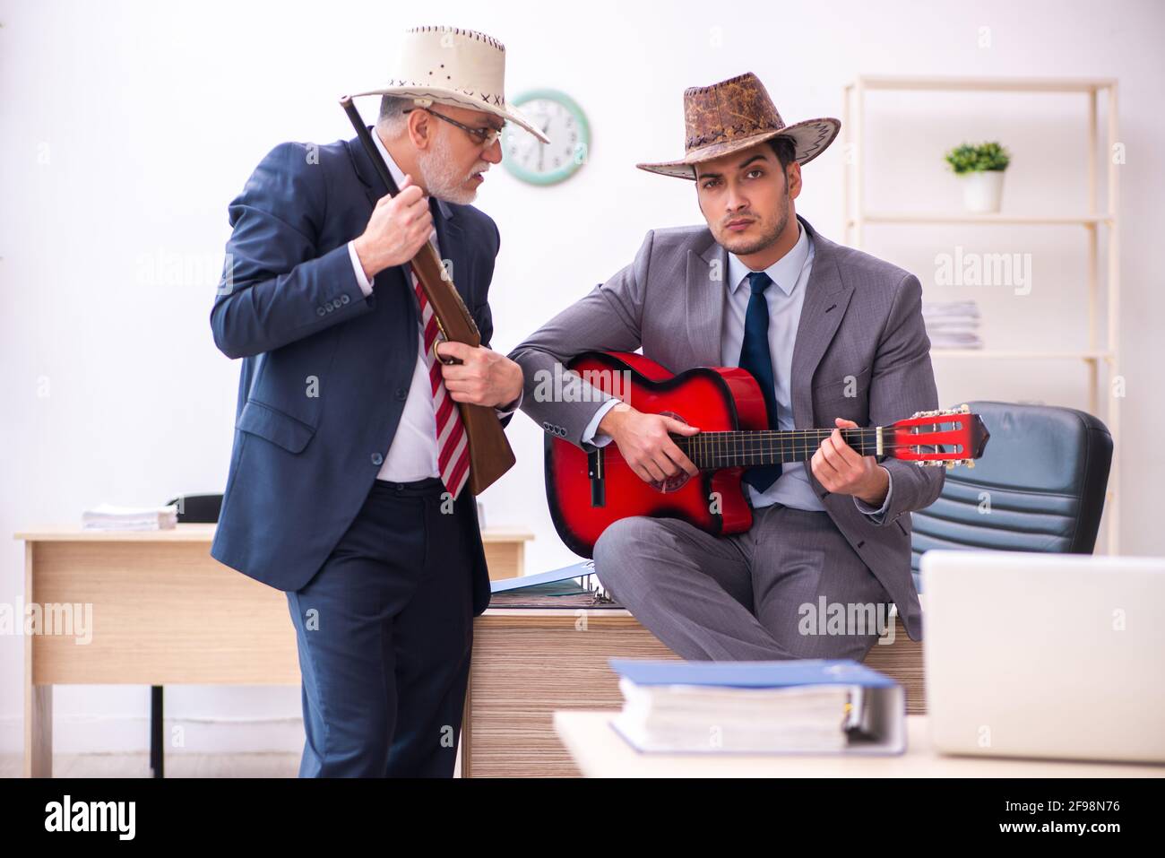 Two male cowboy employees during break in the office Stock Photo - Alamy