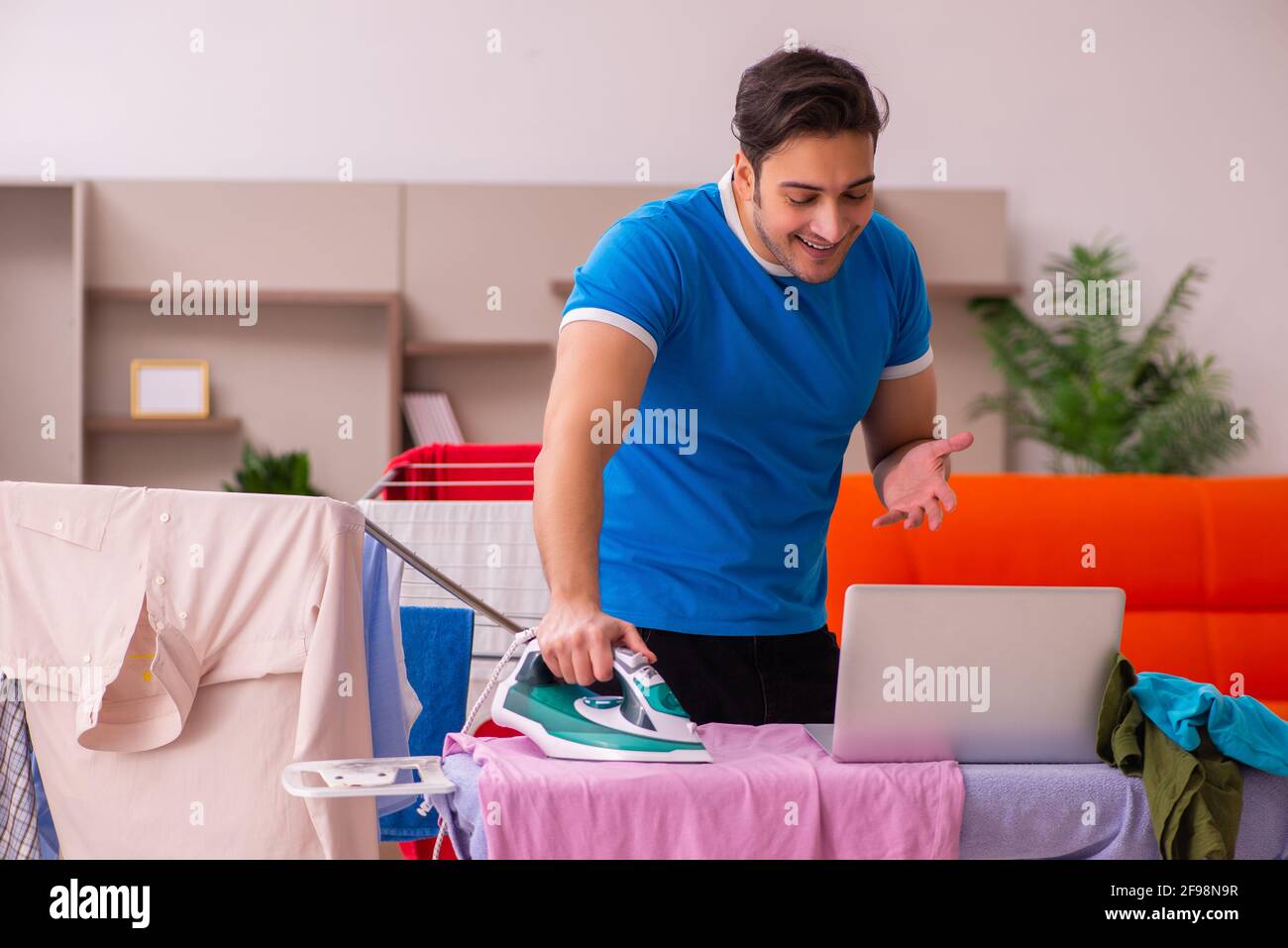 Young man doing ironing at home Stock Photo - Alamy