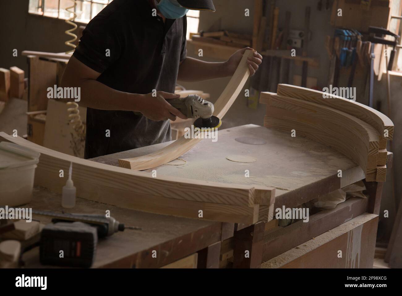 Closeup of a carpenter polishing wood lumber in the workshop with a ...