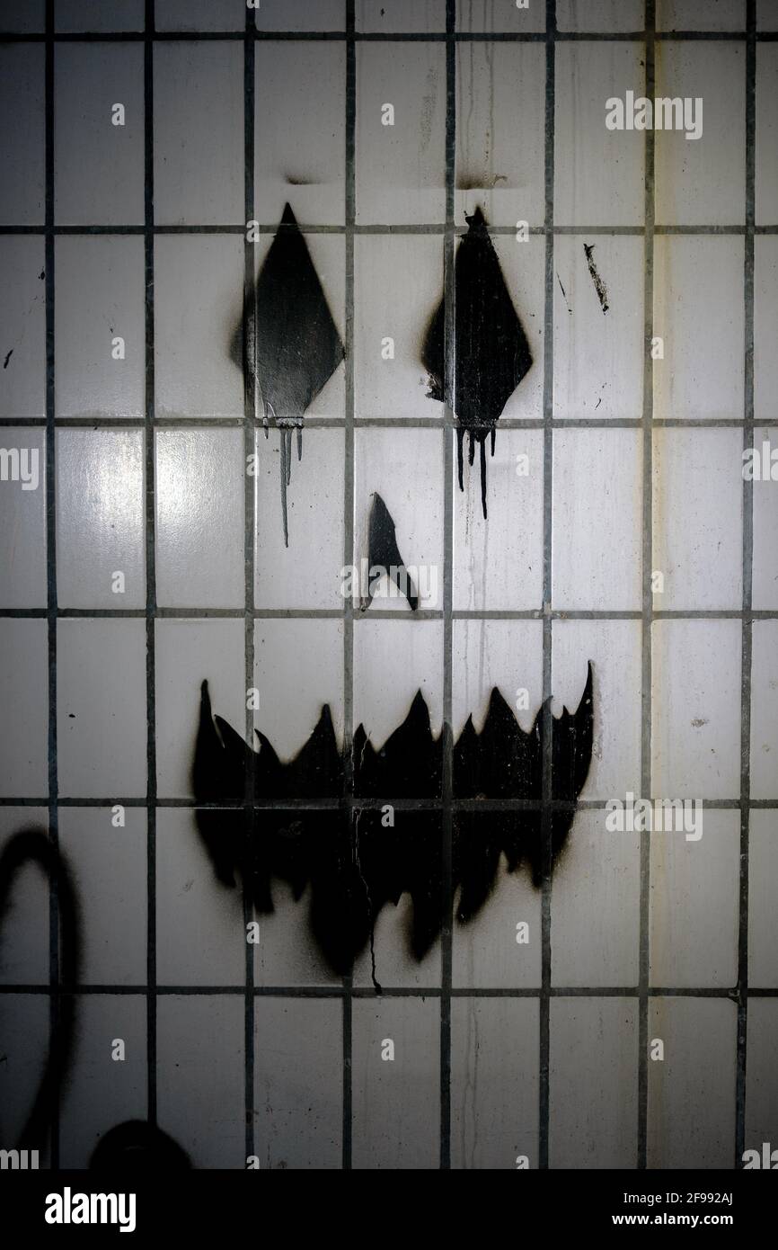 Vertical shot of a scary picture on the white wall background Stock ...
