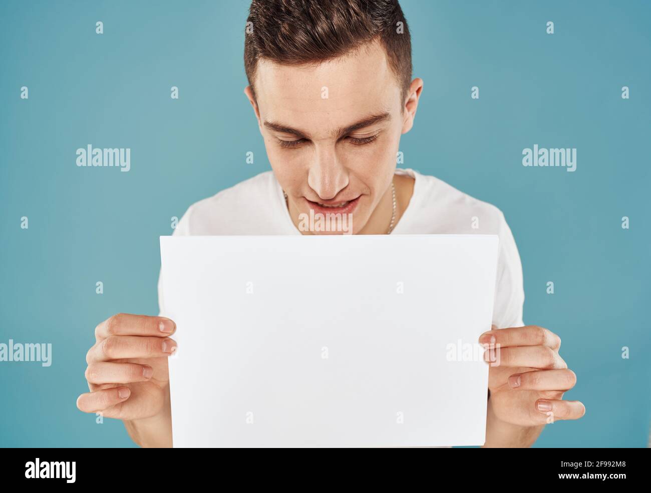 guy with flyer in hand Poster mockup blue background cropped view Stock ...