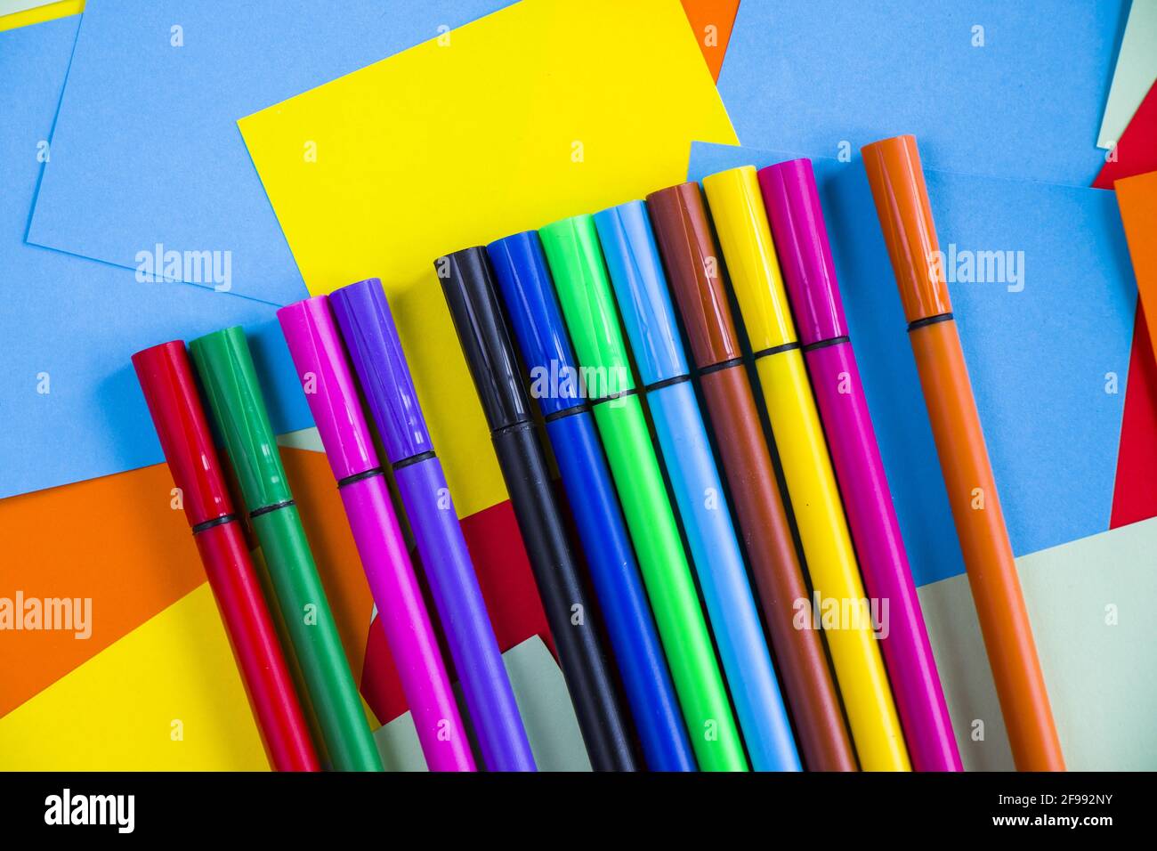 An overhead shot of a set of sketch markers on colorful blank note ...