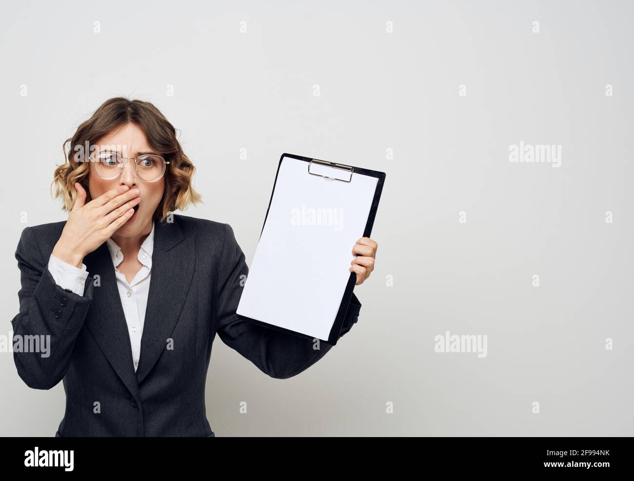 Puzzled woman with documents in hands job office mockup Stock Photo - Alamy