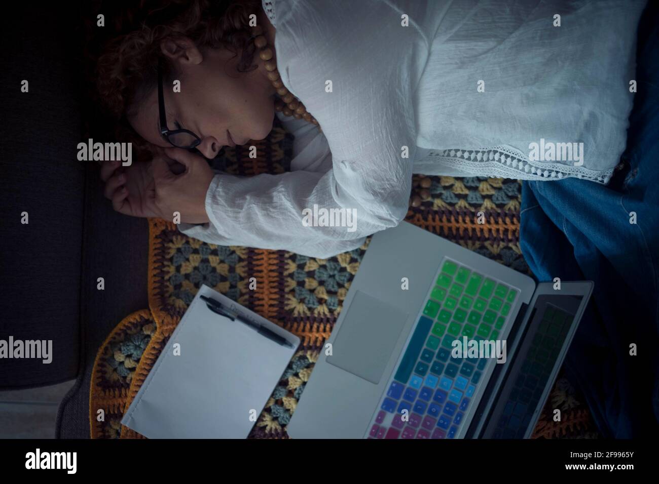 Woman at home by night tired sleep on the sofa with open laptop ...