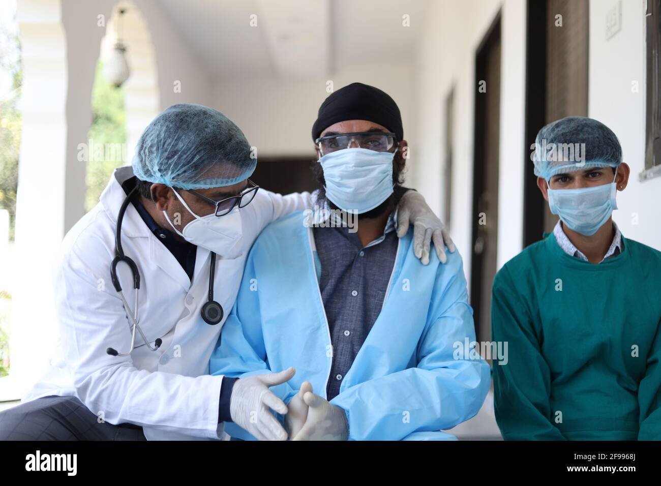 Vertical shot of three Indian doctors with medical uniform and mask on ...