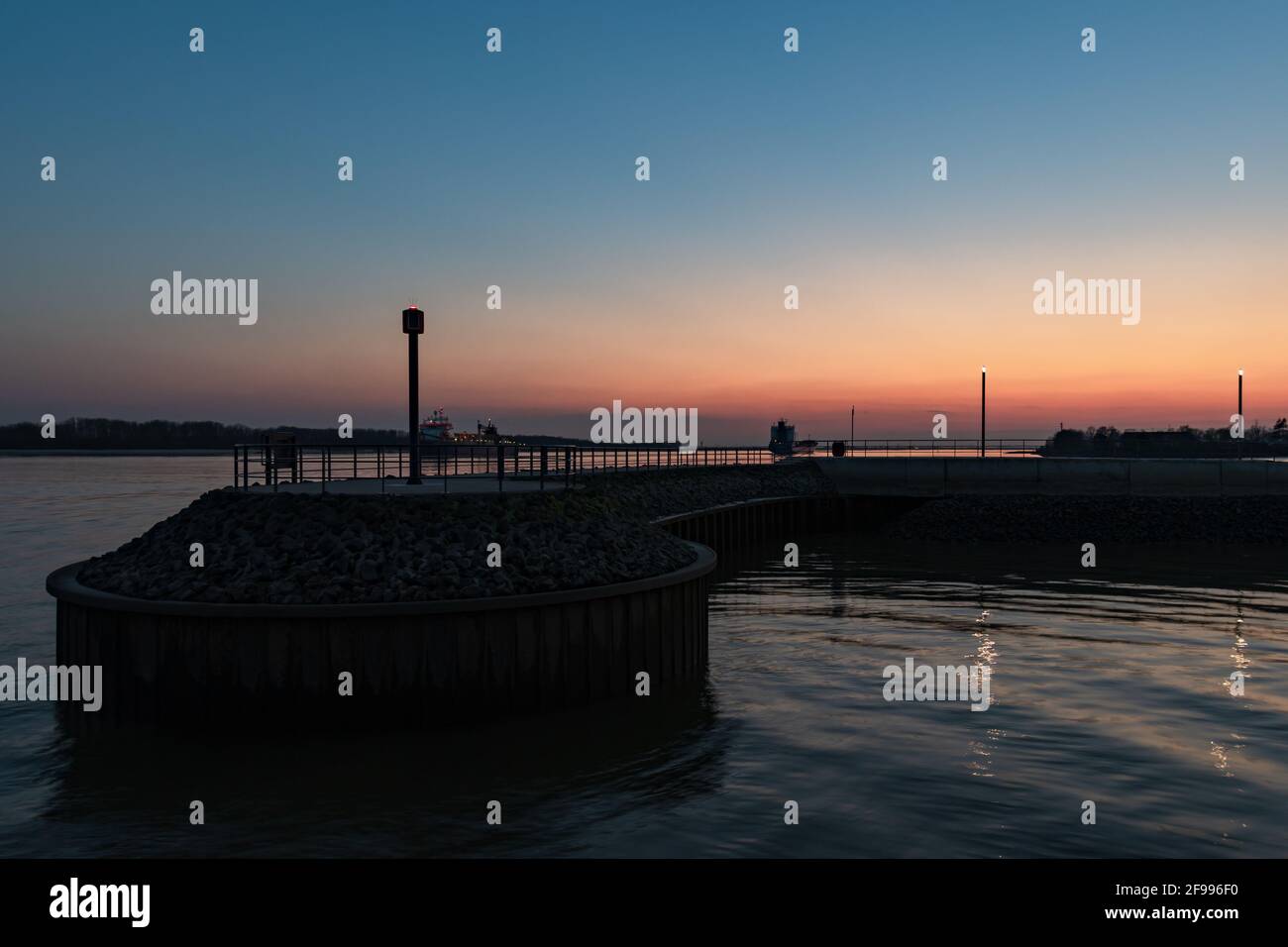 Dock on the beautiful Elbe River gleaming under the pink sky during ...