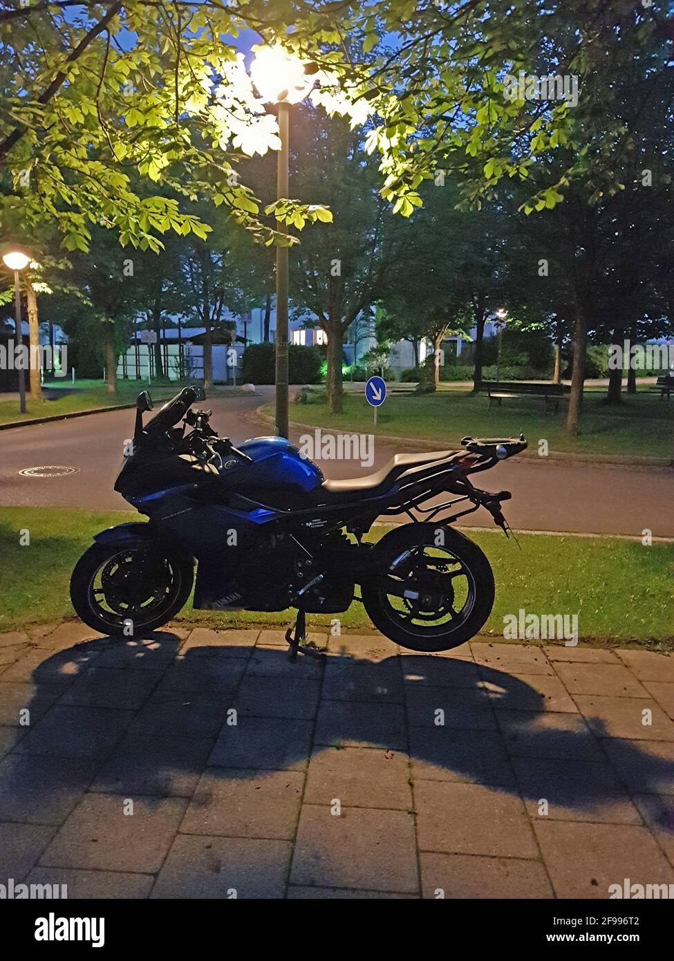Motorbike parked under street lamp Stock Photo - Alamy