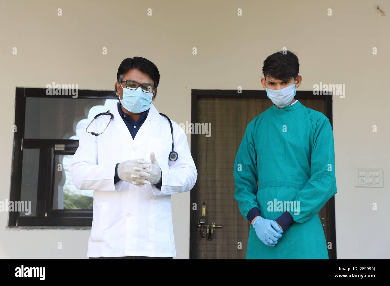 Indian doctor and his assistant with medical uniform and masks standing ...