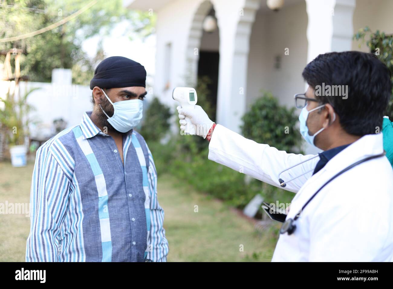 Young doctor measuring the body temperature of her patient with a ...