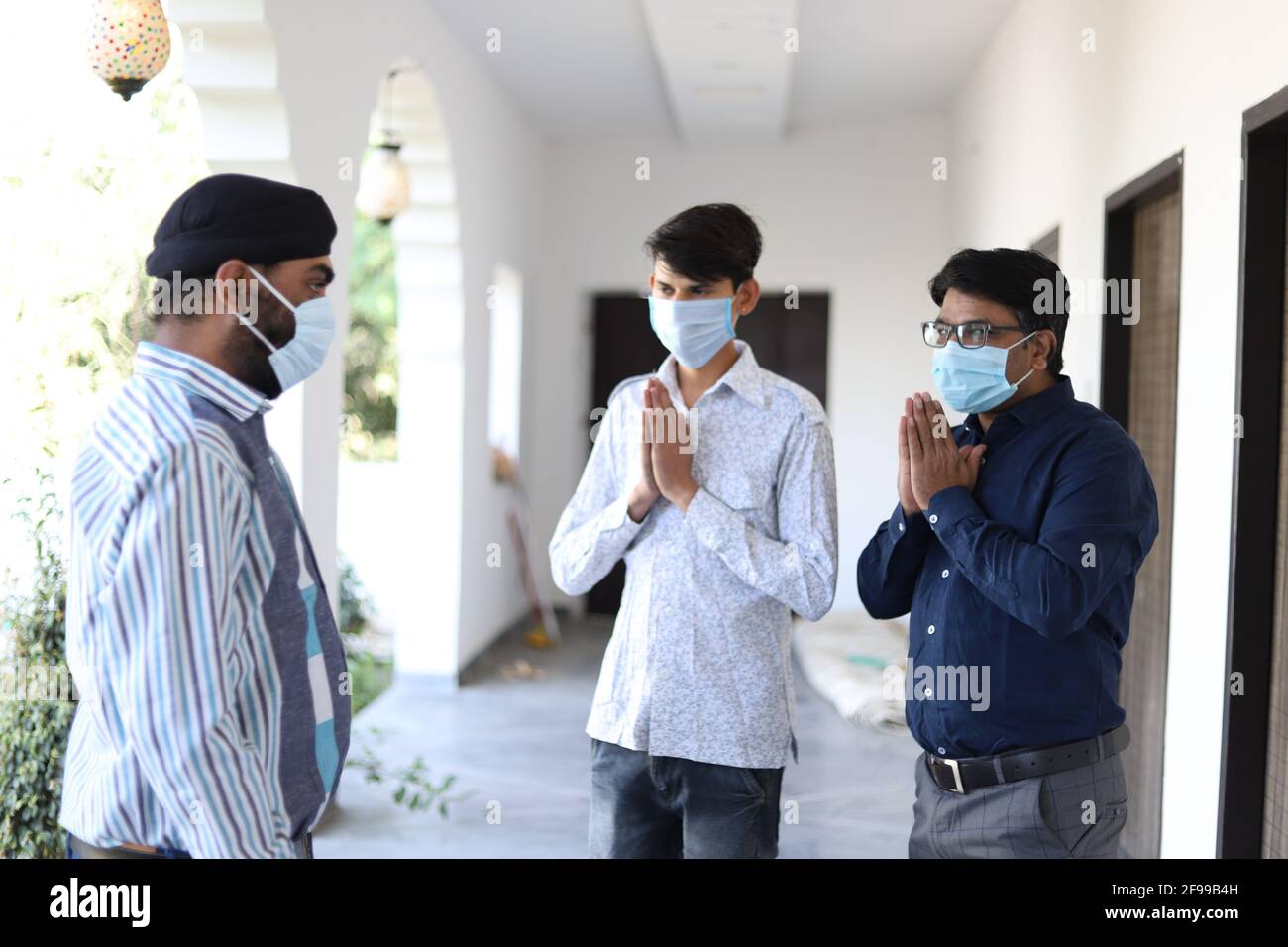 Closeup shot of three Indian men with masks on the clinic background ...
