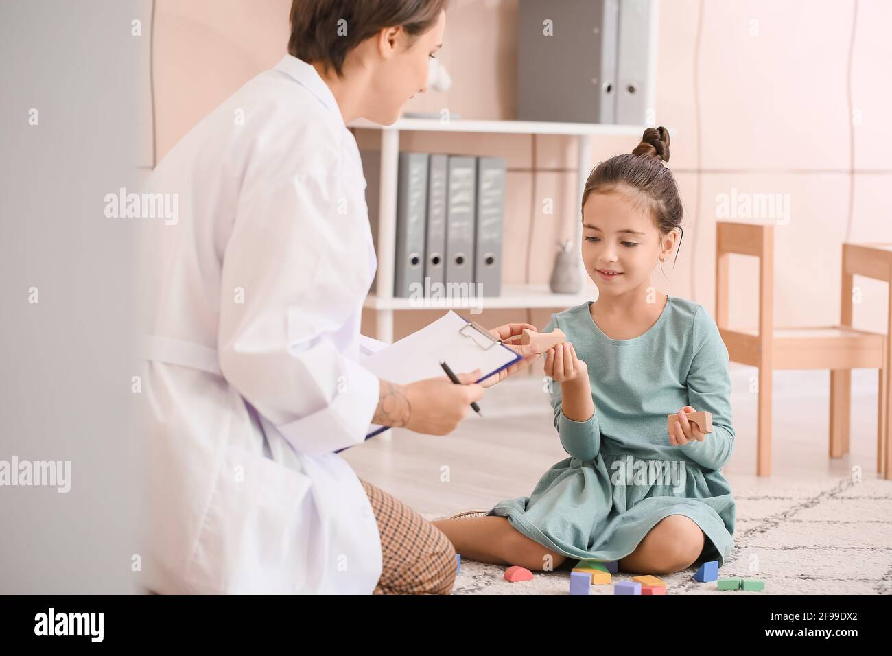 Female psychologist working with little girl at home Stock Photo - Alamy
