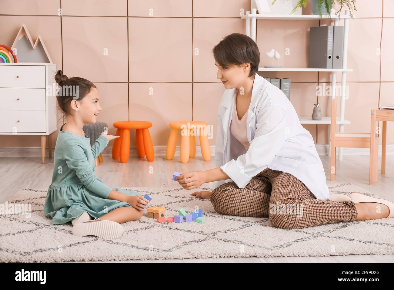 Female psychologist working with little girl at home Stock Photo - Alamy