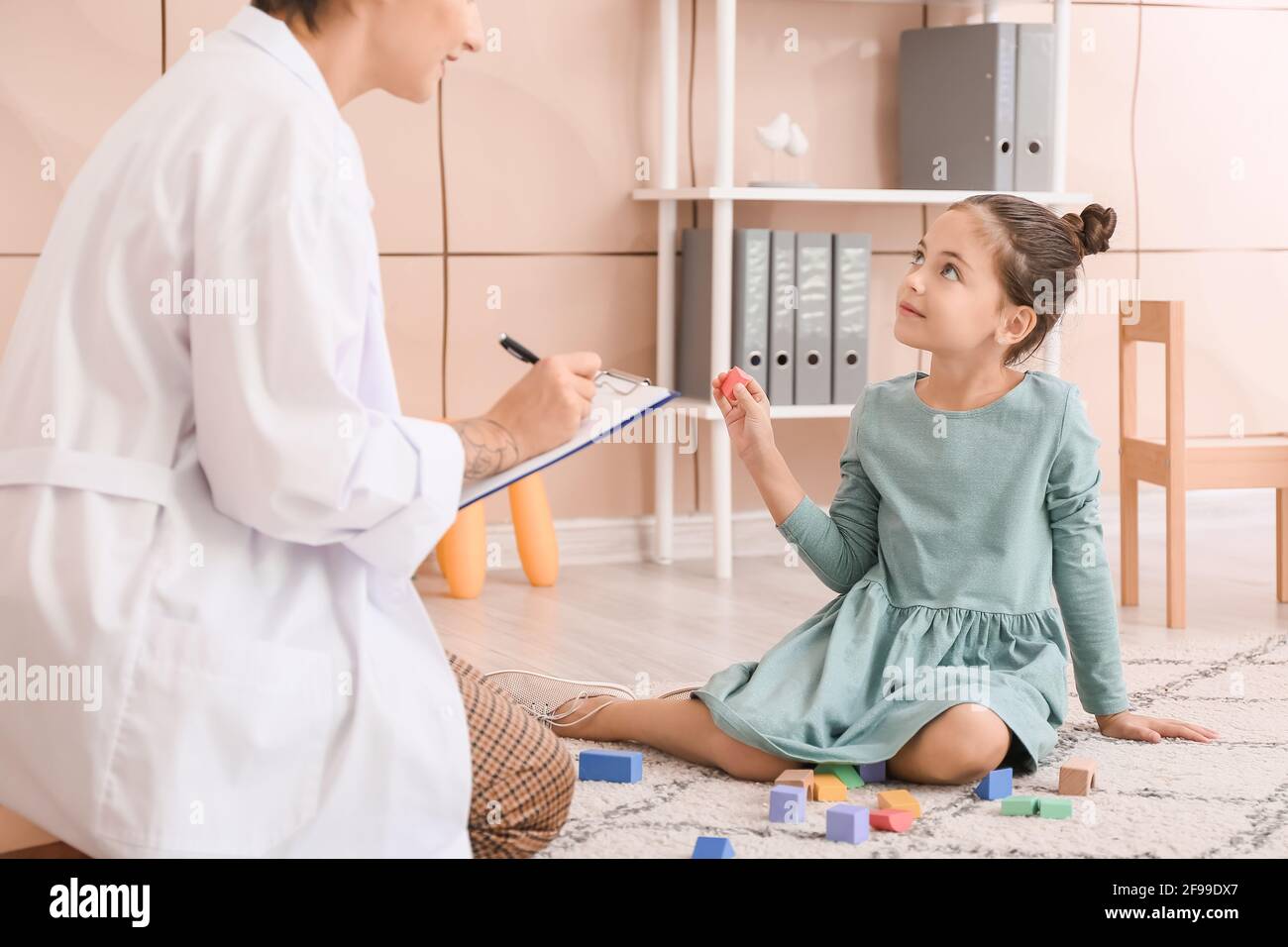 Female psychologist working with little girl at home Stock Photo - Alamy
