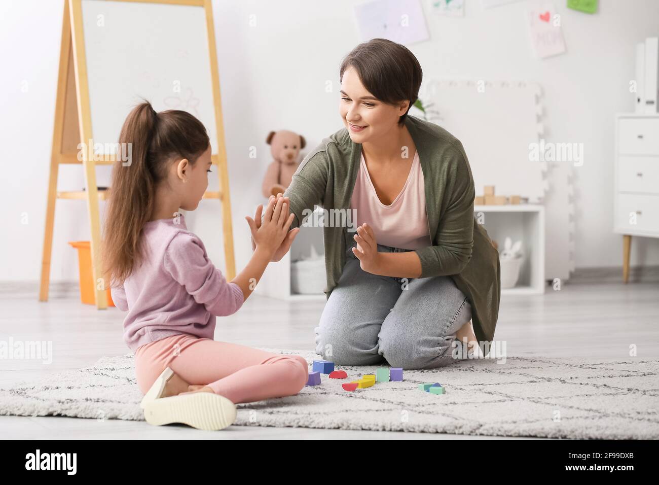 Female psychologist working with little girl at home Stock Photo - Alamy