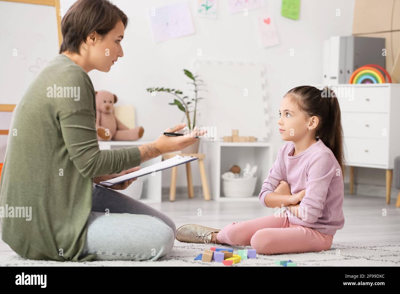 Female psychologist working with little girl at home Stock Photo - Alamy