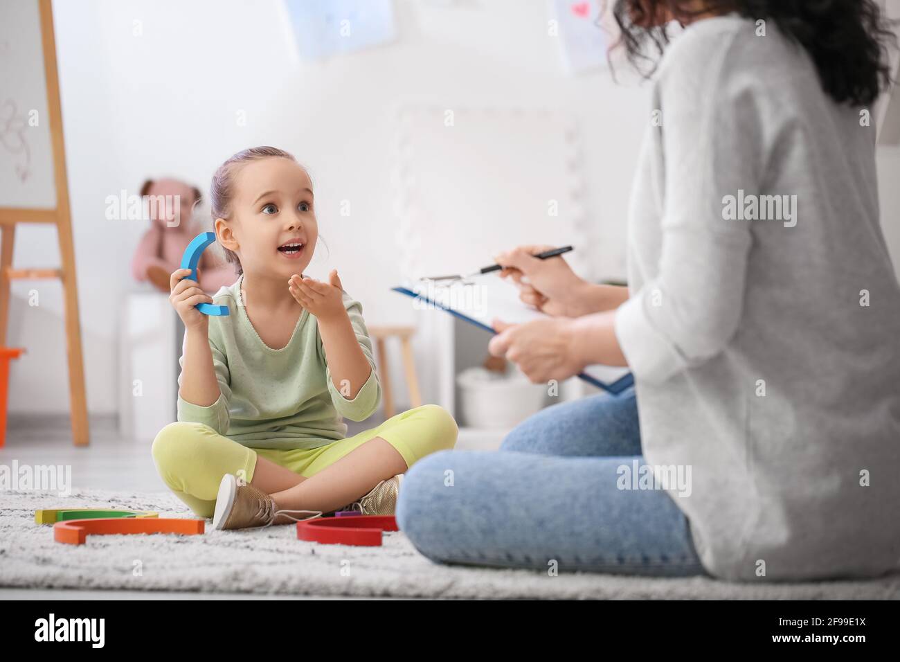 Female psychologist working with little girl at home Stock Photo - Alamy