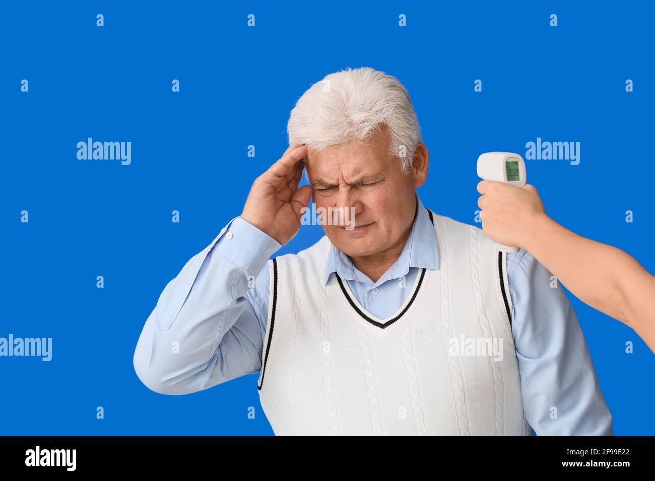 Measuring of sick senior man's temperature on color background Stock ...