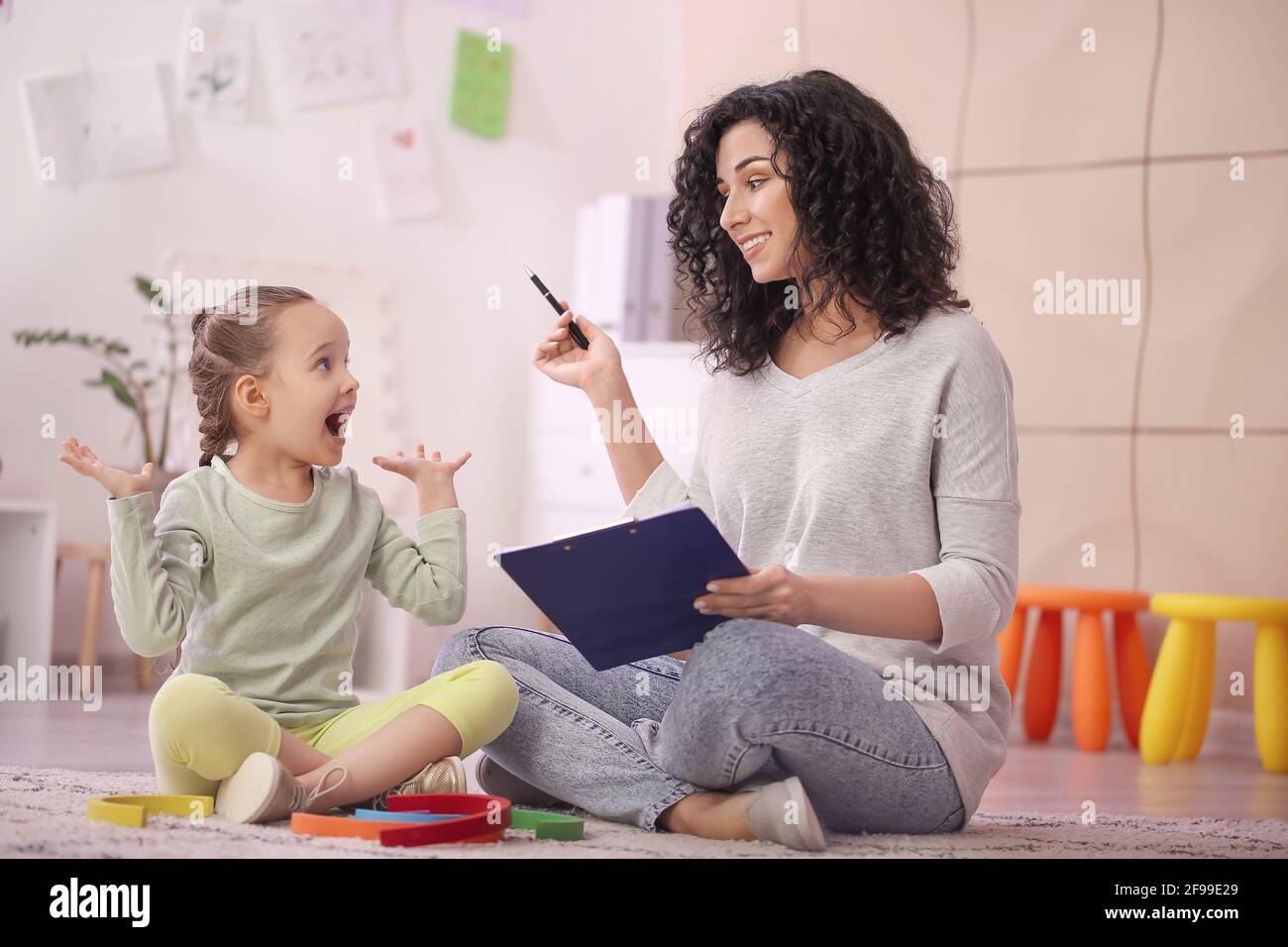 Female psychologist working with little girl at home Stock Photo - Alamy